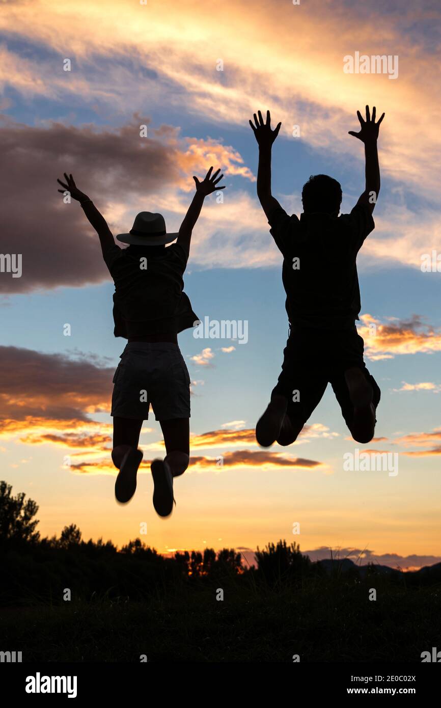 The jump in the sunset happy couples Stock Photo - Alamy