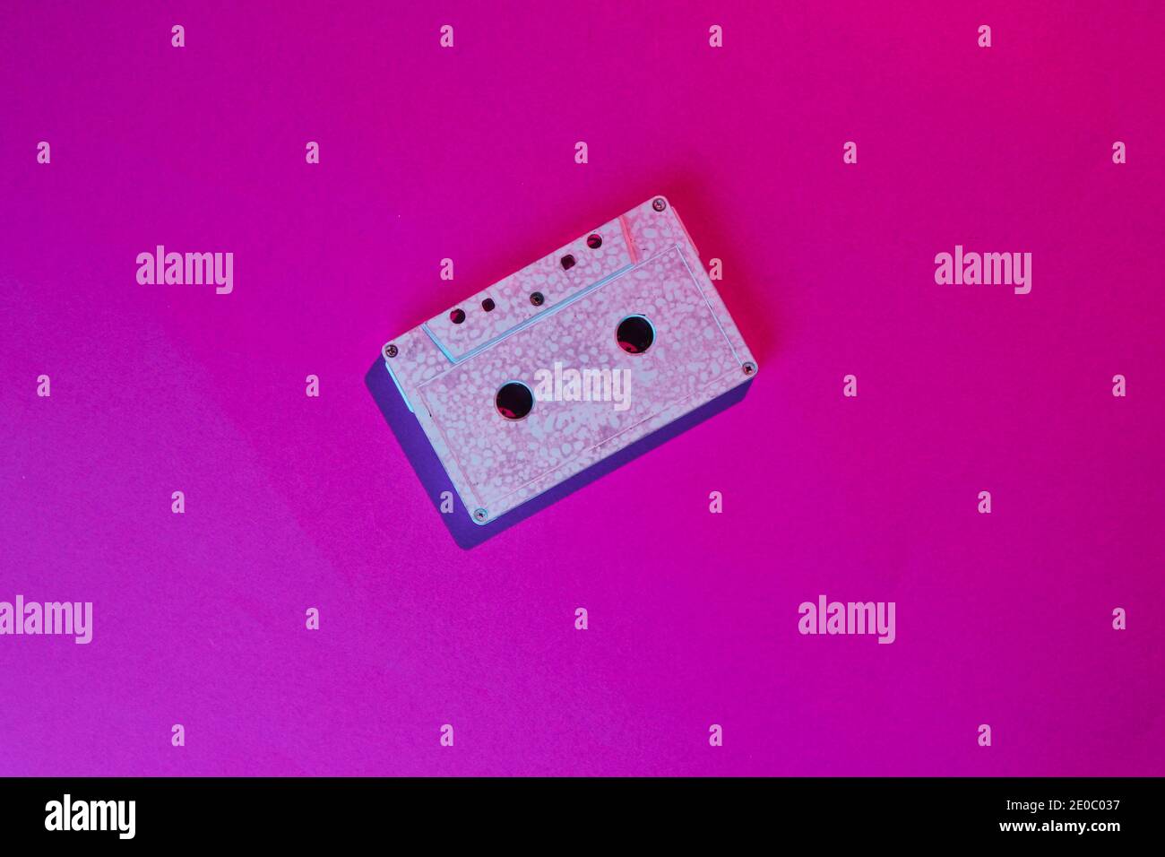 Retro wave style audio cassette with neon pink-violet light. 80s. Top ...