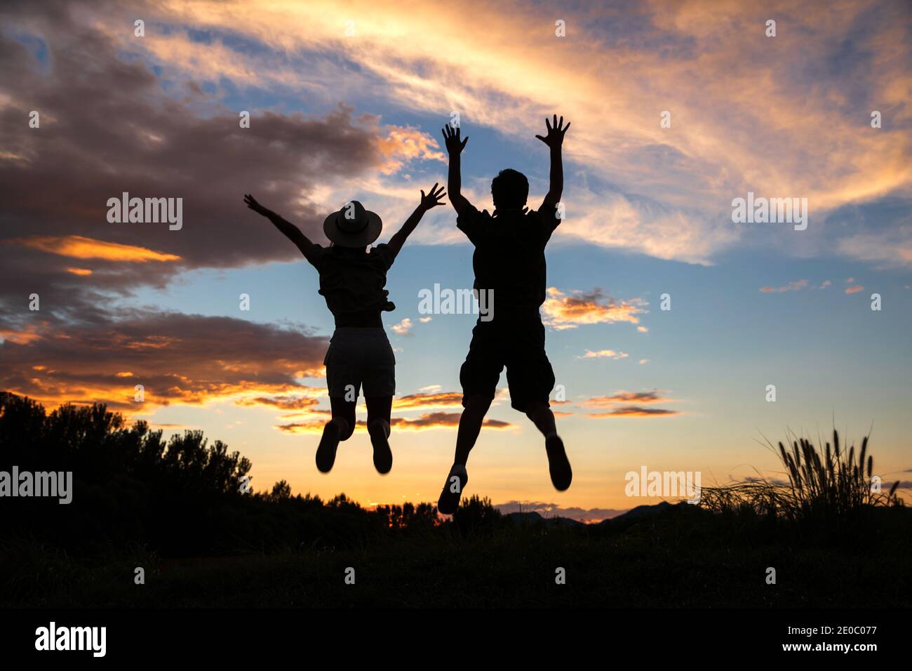 The jump in the sunset happy couples Stock Photo - Alamy
