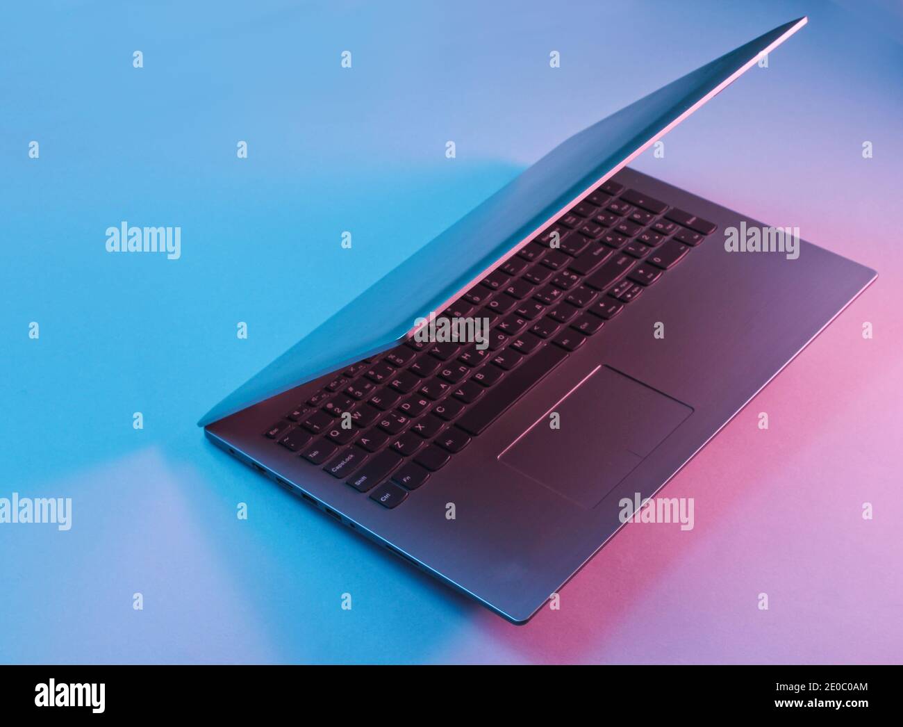 Modern laptop with vibrant gradient pink blue neon lights. Minimal ...