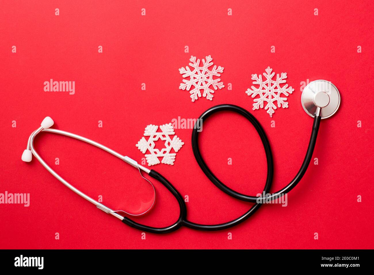 Christmas medicine red background with stethoscope and snowflakes ...