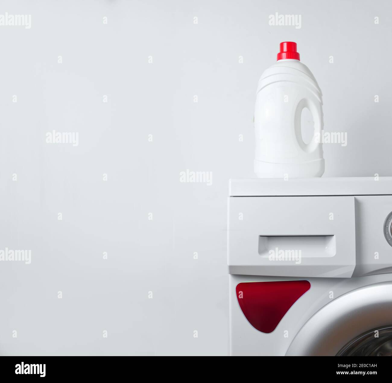 Bottle of washing gel on a washing machine. White background for copy ...