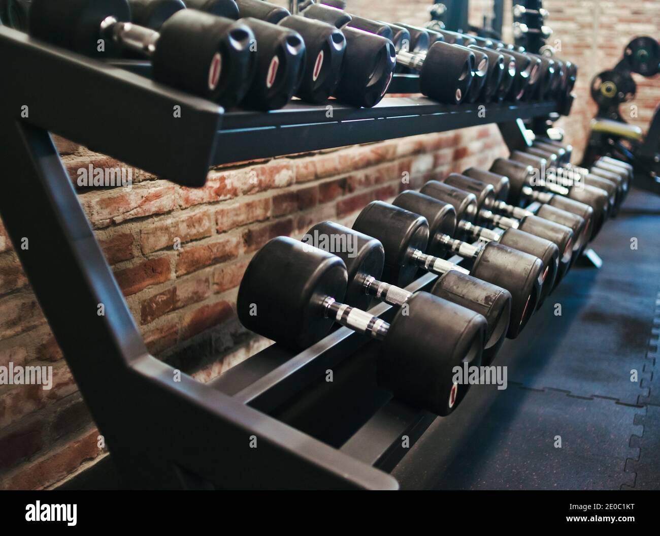 Set of black dumbbell with metal handles on a rack in the gym. Free ...