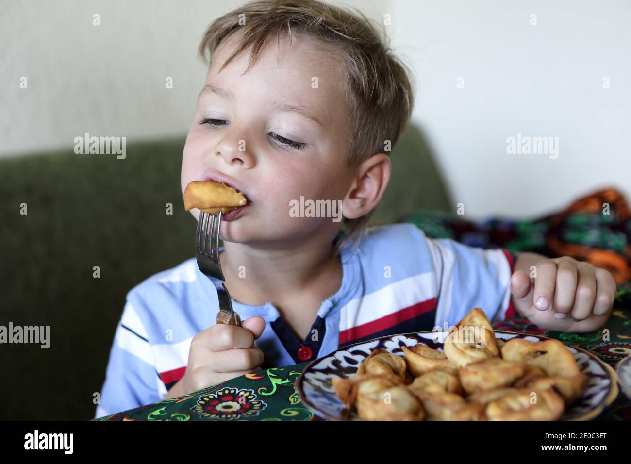 Child eating fried dumplings in a restaurant Stock Photo - Alamy