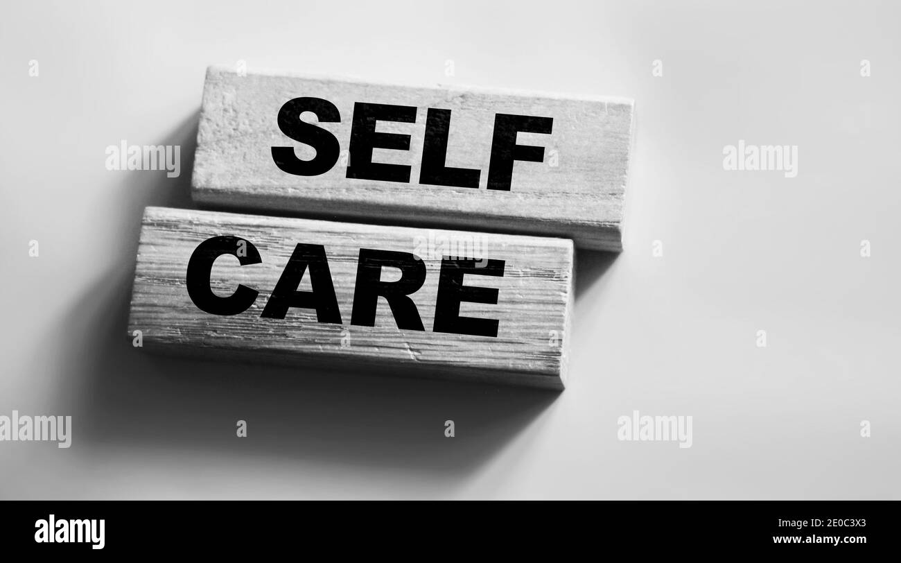 Self care words printed on wooden blocks, self treatment concept, pink ...