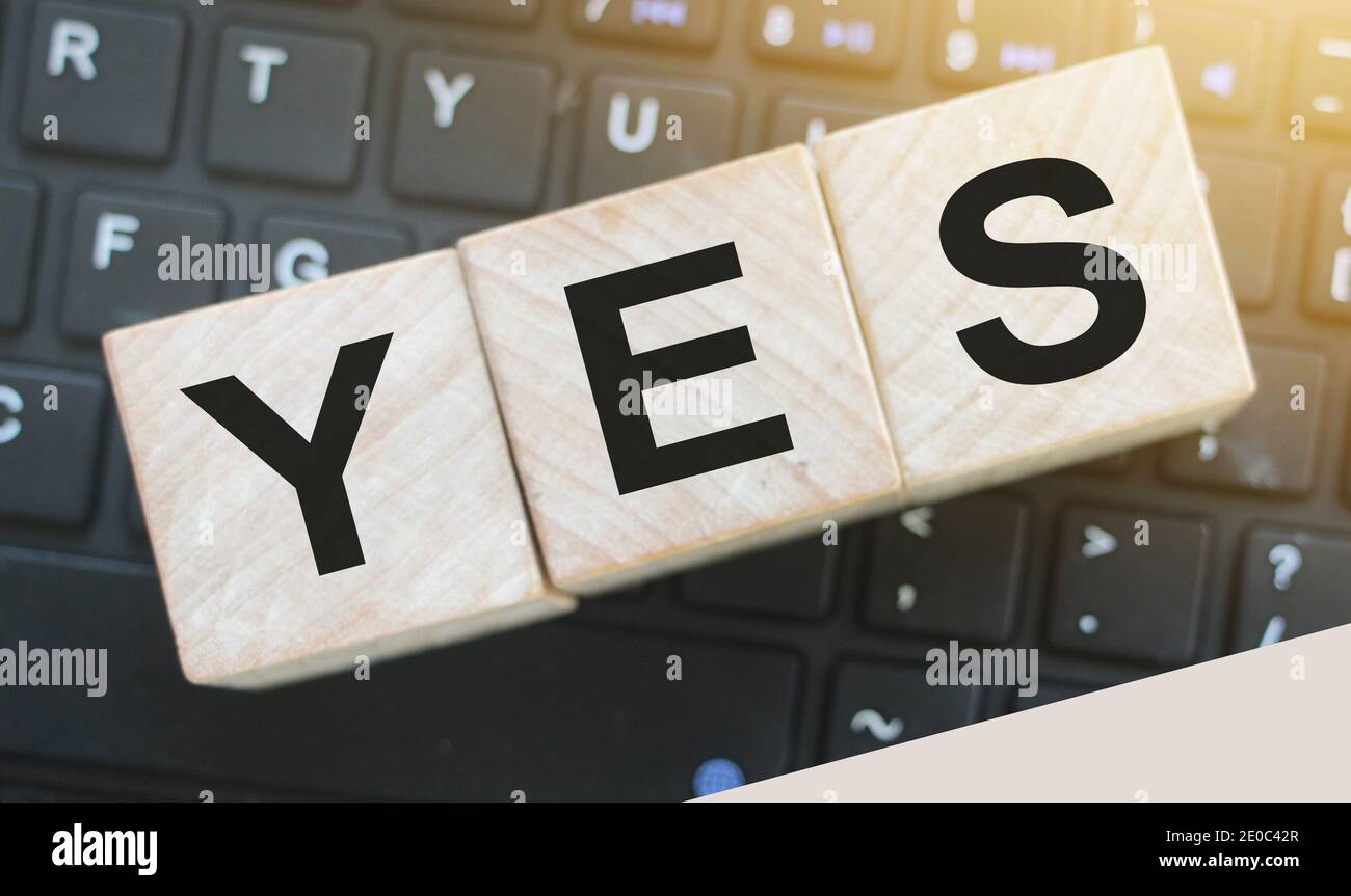 The word Yes on wooden blocks on computer keyboard. Business ...