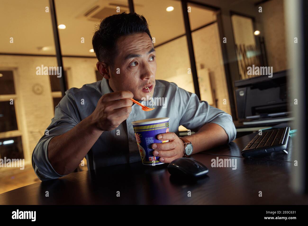 Young men in the office to work overtime to eat instant noodles Stock ...
