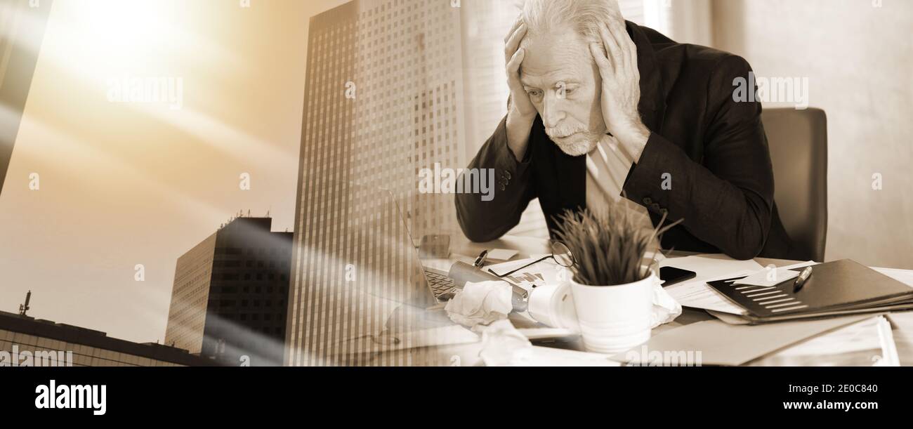 Overworked senior businessman sitting at a messy desk; multiple ...