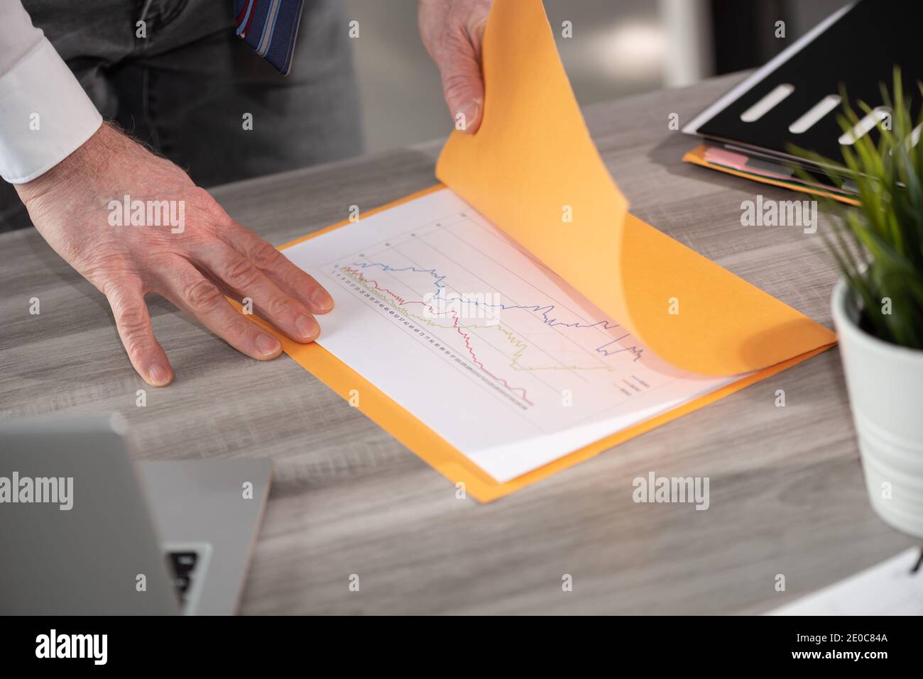 Businessman opening folder with paper documents Stock Photo - Alamy