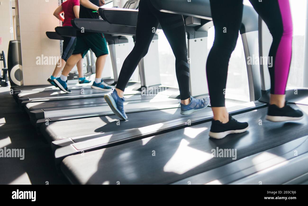Group of people in sportswear running around on a treadmill. Cardio ...