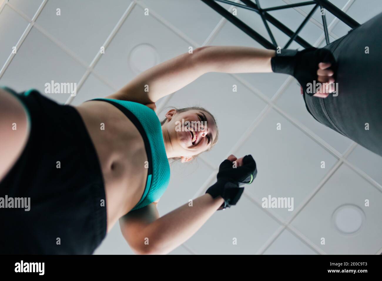 Bottom view female boxer training a punch with a punching bag. Sport ...