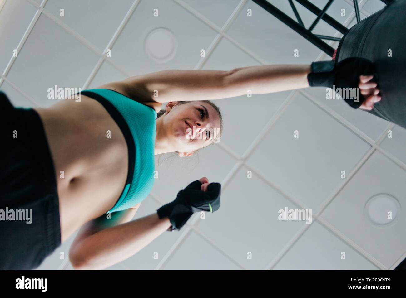 Bottom view female boxer training a punch with a punching bag. Sport ...
