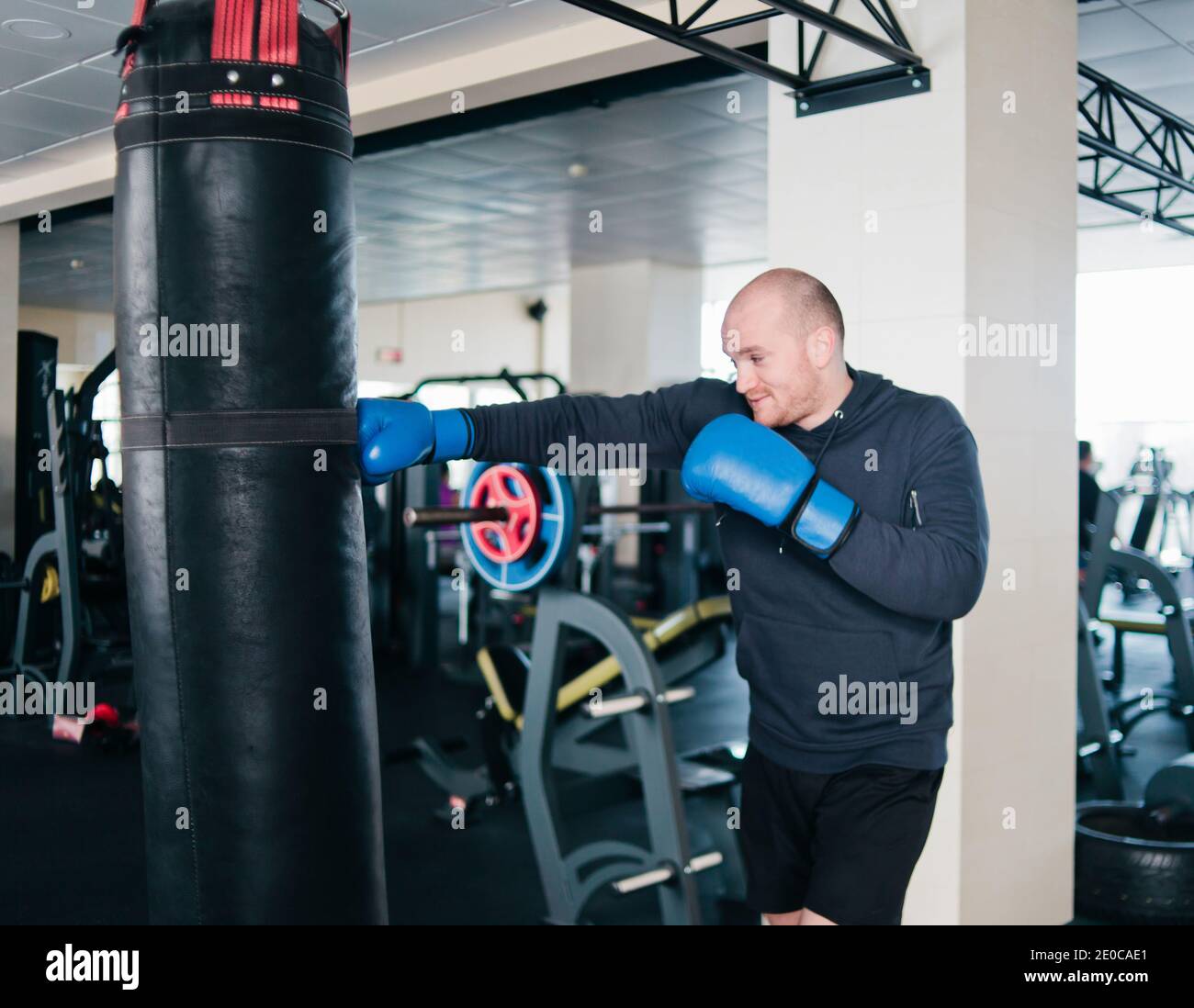 Man in boxing gloves boxing with a punching bag in the gym Stock Photo ...