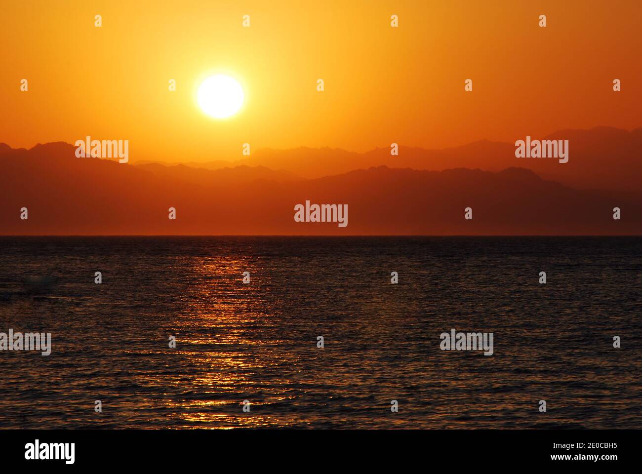 Shining warm sunrise on the sea with bergen left Stock Photo - Alamy