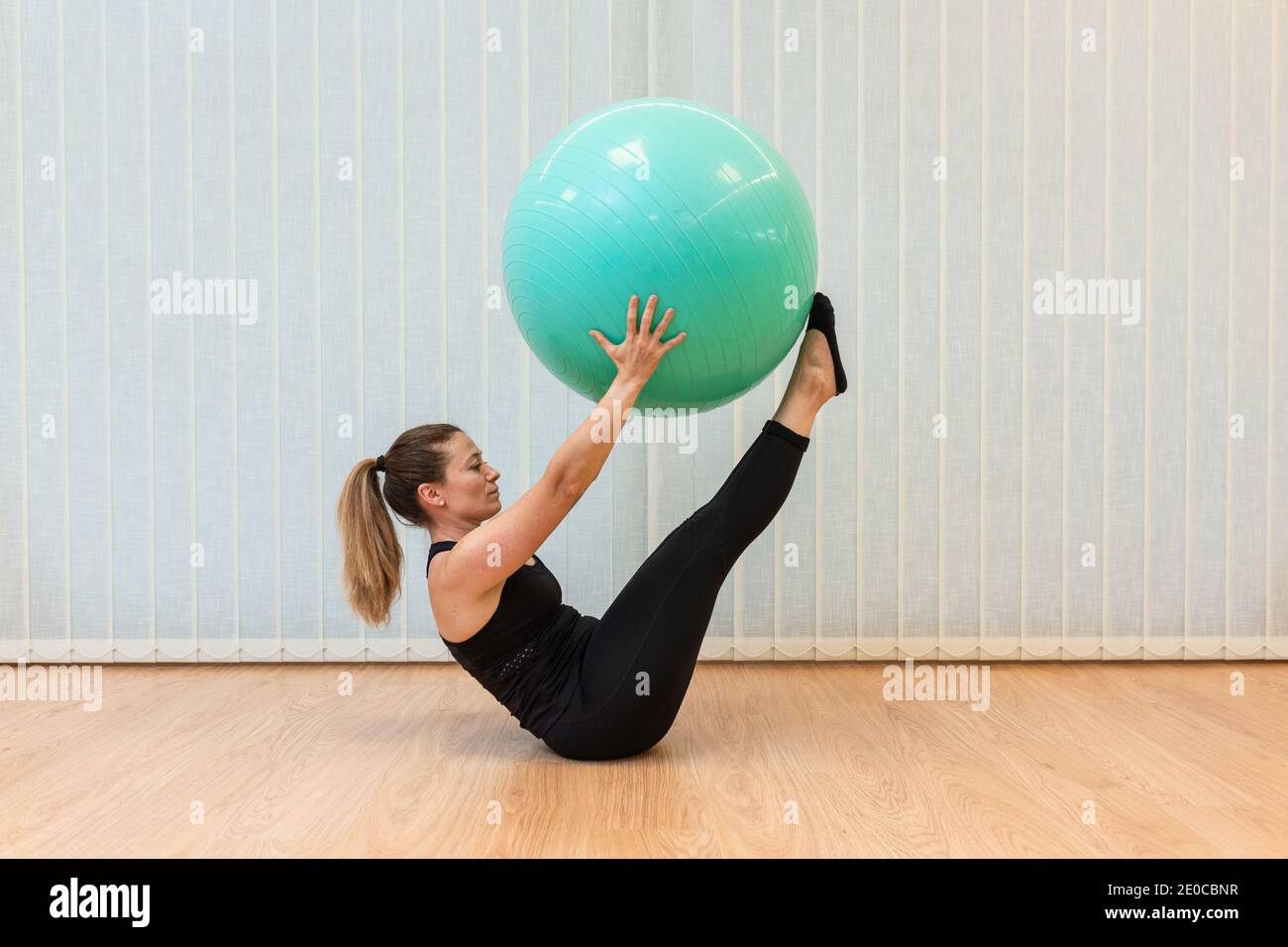 girl pilates trainer does V fitball posture in fitness center Stock ...