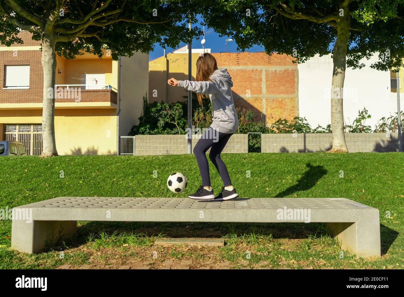 Cute little girl playing soccer in a nice park with natural grass, she ...