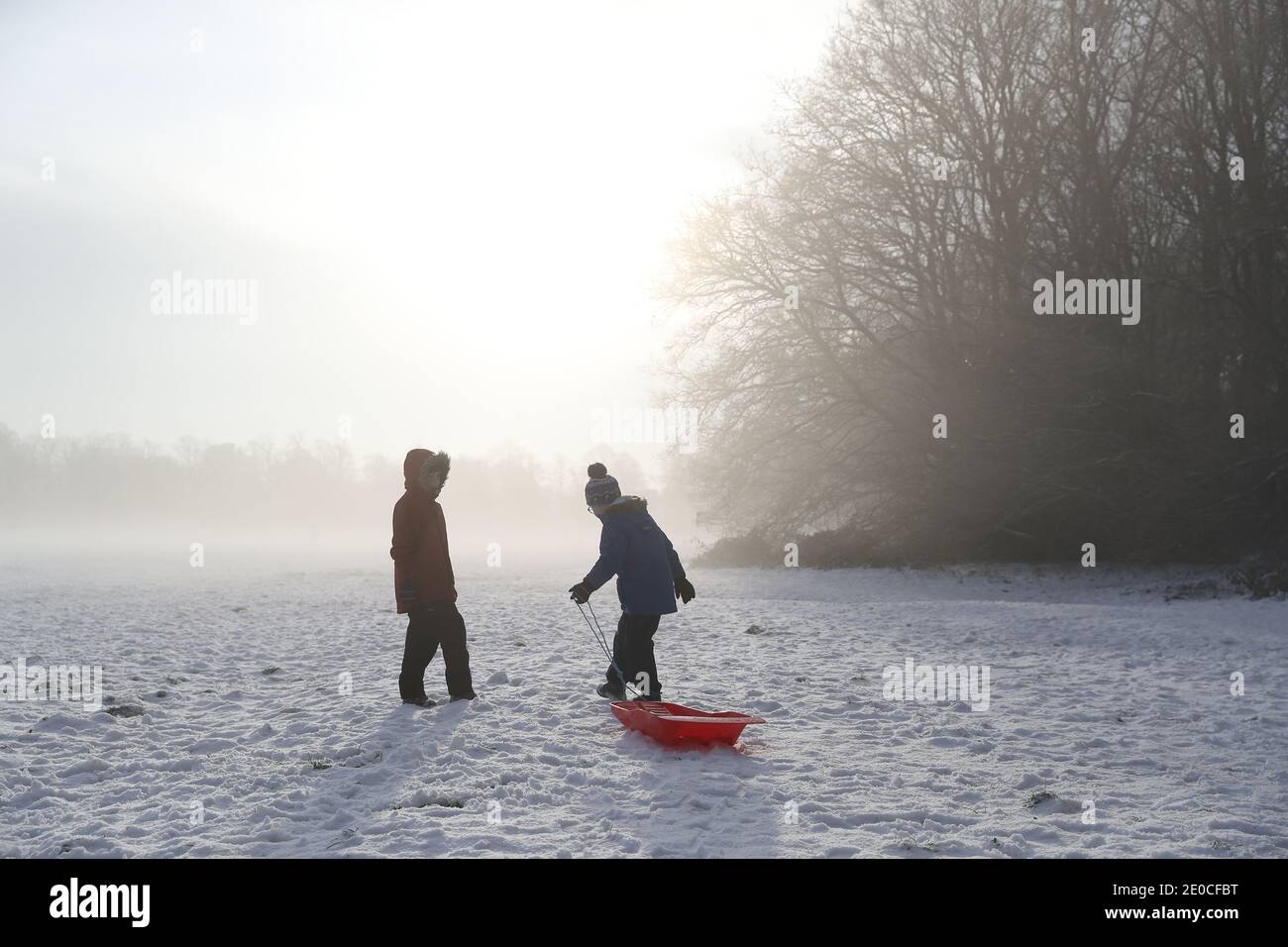 Two children drag a sledge across Knutsford Heath in Cheshire after ...
