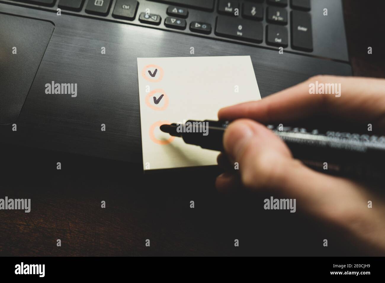 Check boxes on white paper plans. hand with black marker makes marks in ...