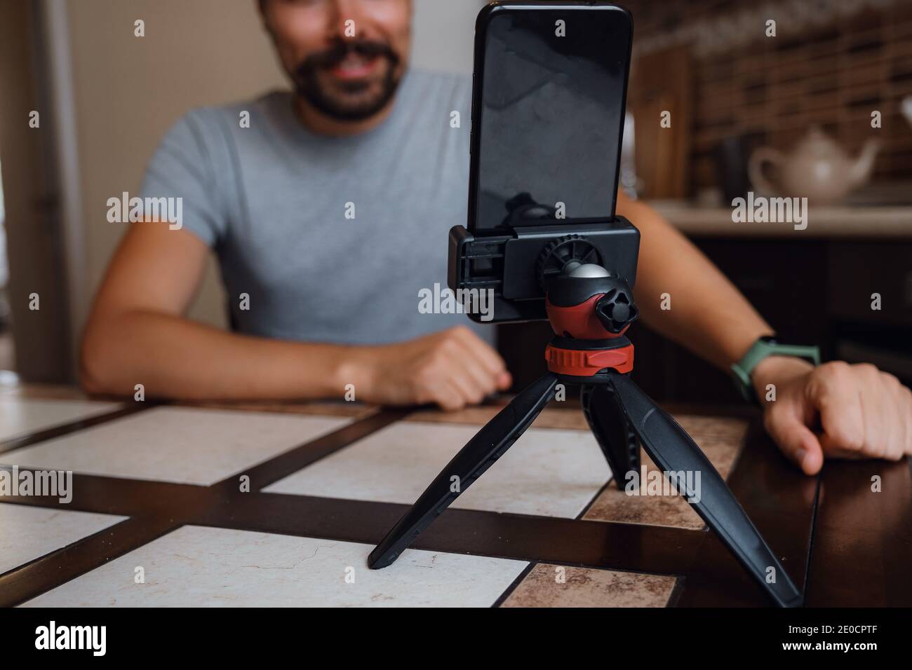 Young man having video call via smartphone in the home office. Virtual ...