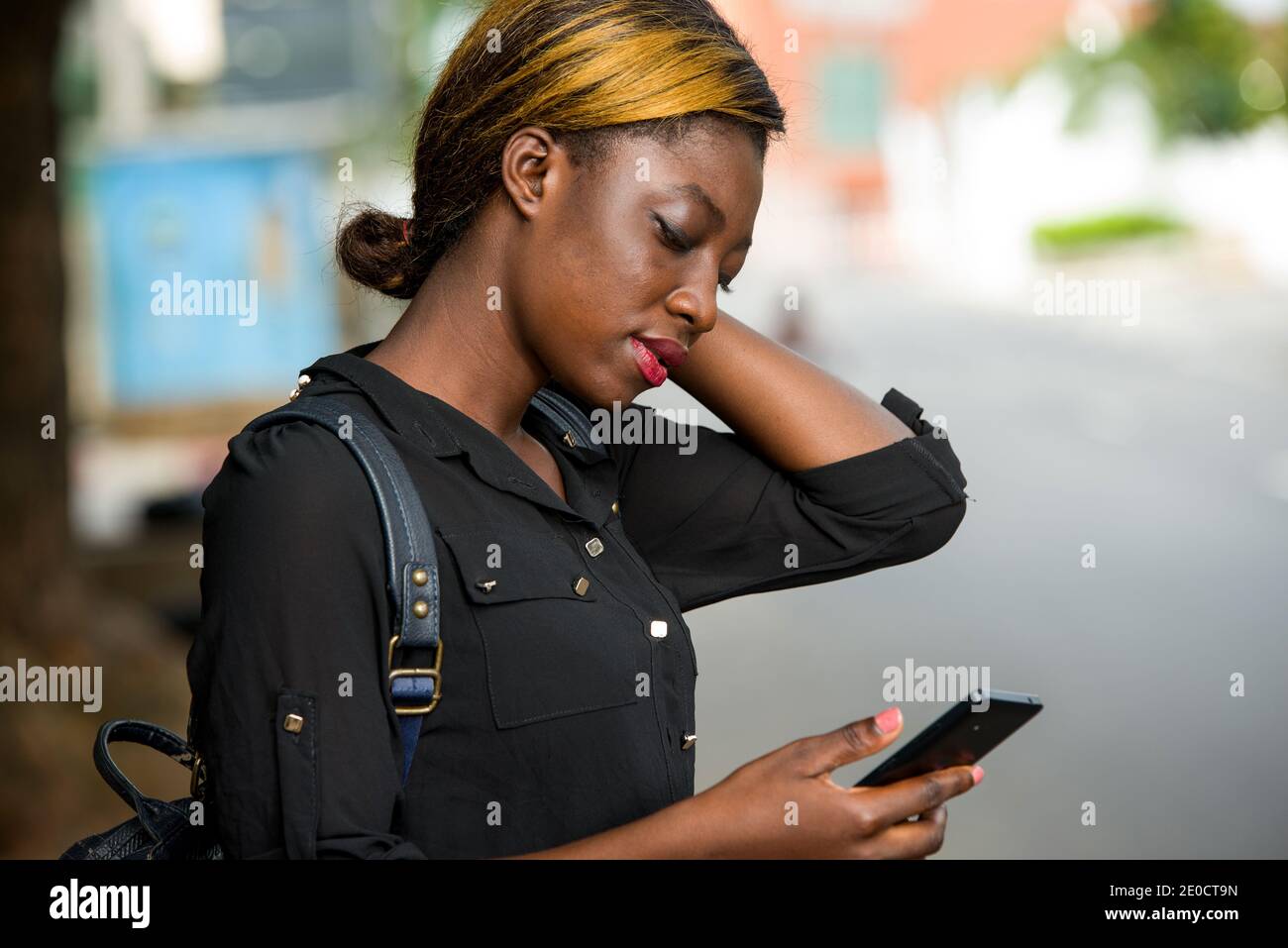 portrait of young student checking smart phones outdoors in a ...