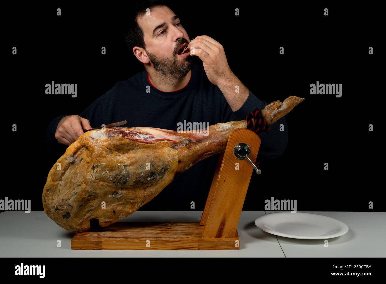 Bearded man with a ham knife ready to cut a piece of typical Spanish ...