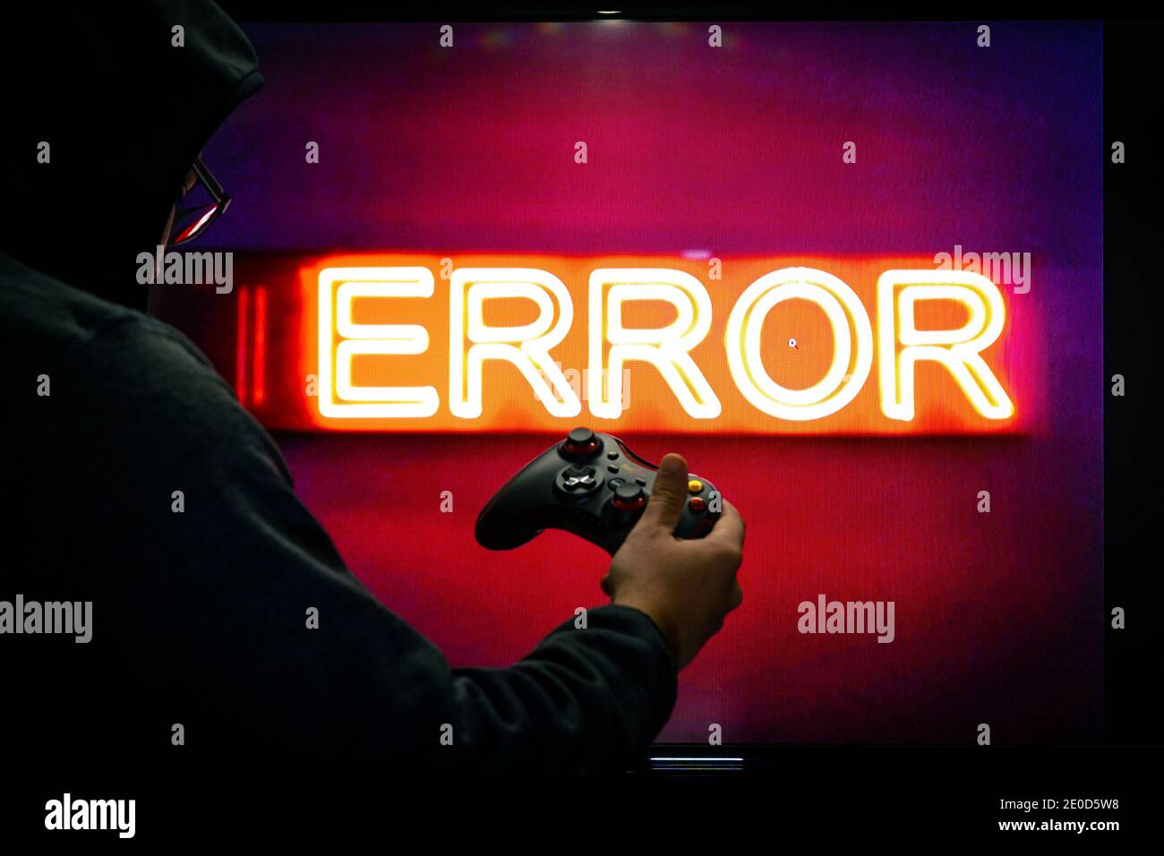 Man holding a controller in front of a screen showing an error message ...
