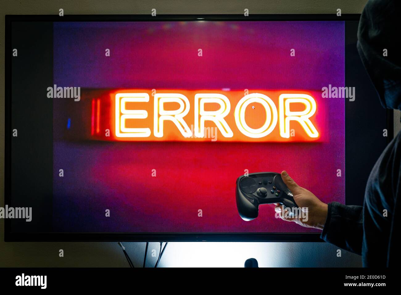 Man holding a controller in front of a screen showing an error message ...