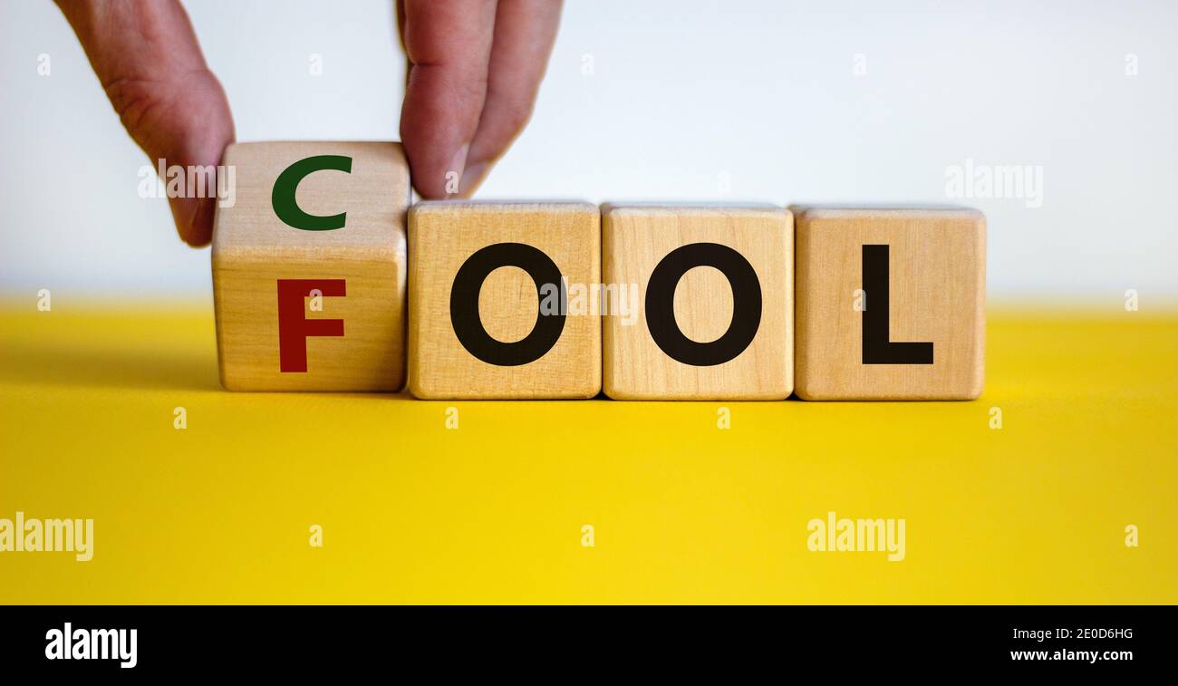 Do not be a fool just play cool symbol. Male hand turns wooden cubes ...