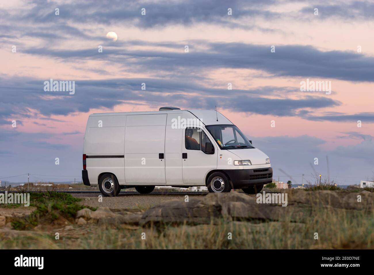 Camper van at sunset with moon behind on a nature landscape place ...