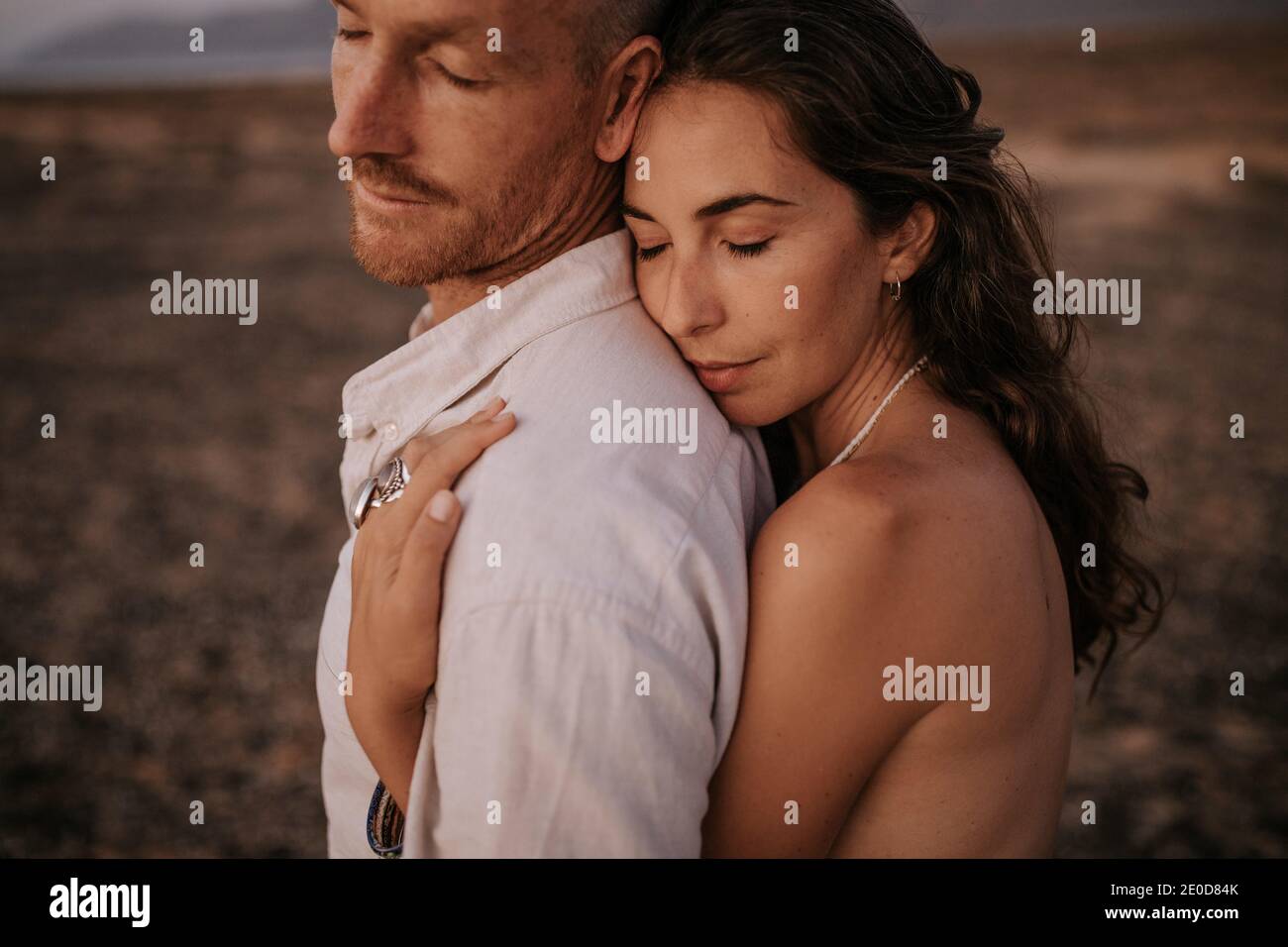Side view of gentle Woman embracing man from back while standing with ...