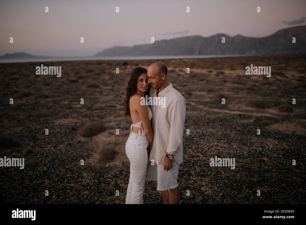 Side view of peaceful couple in white outfit standing together in ...