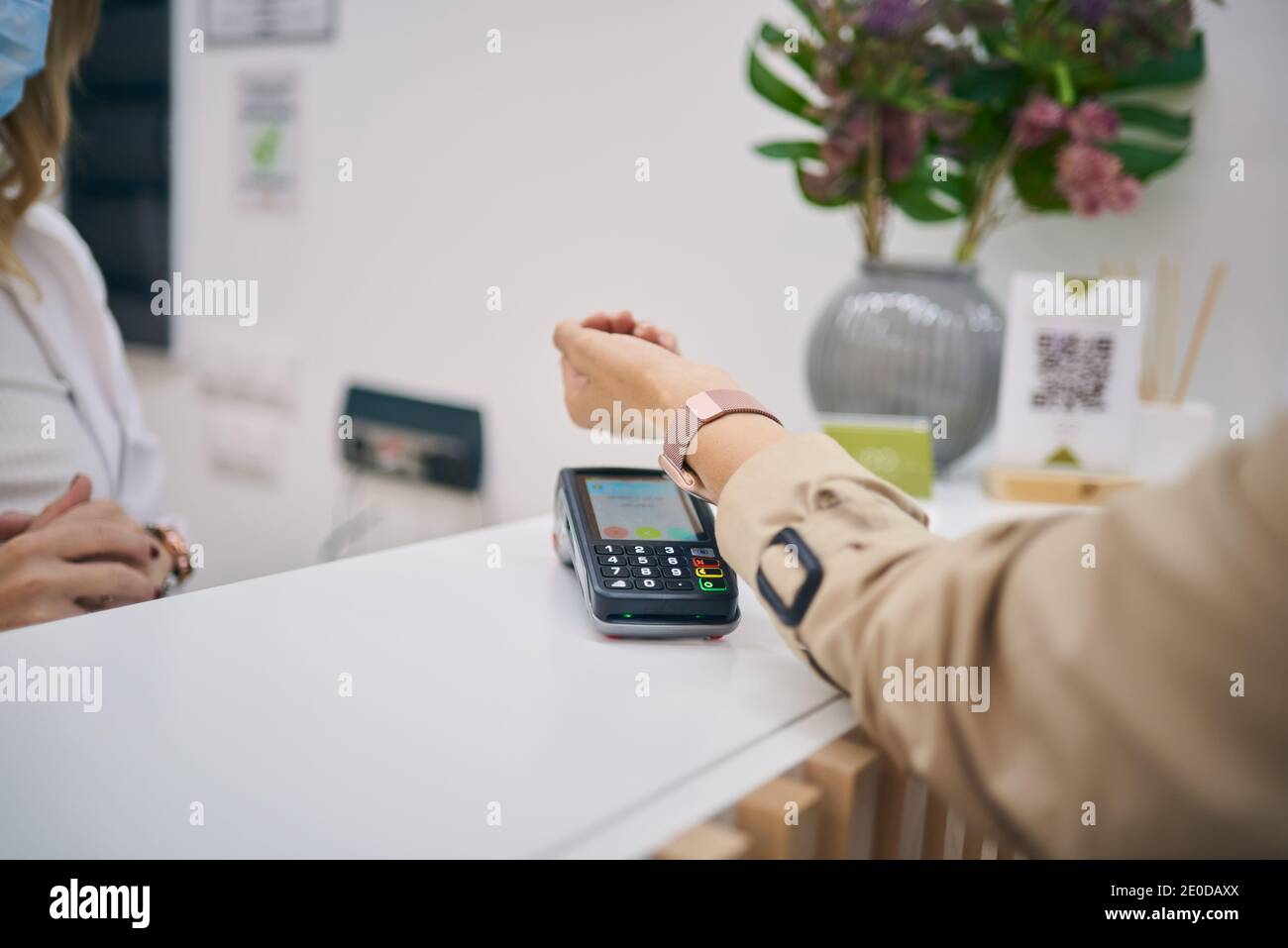 Unrecognizable female client making payment on POS terminal with smart ...