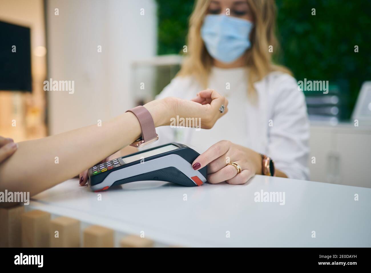 Unrecognizable female client making payment on POS terminal with smart ...