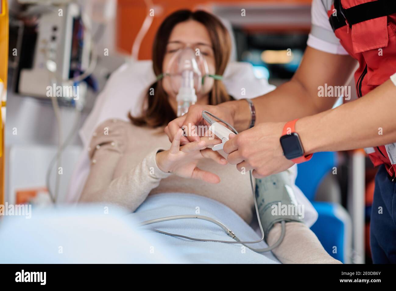Crop male paramedic putting finger pulse oximeter on patient in ...