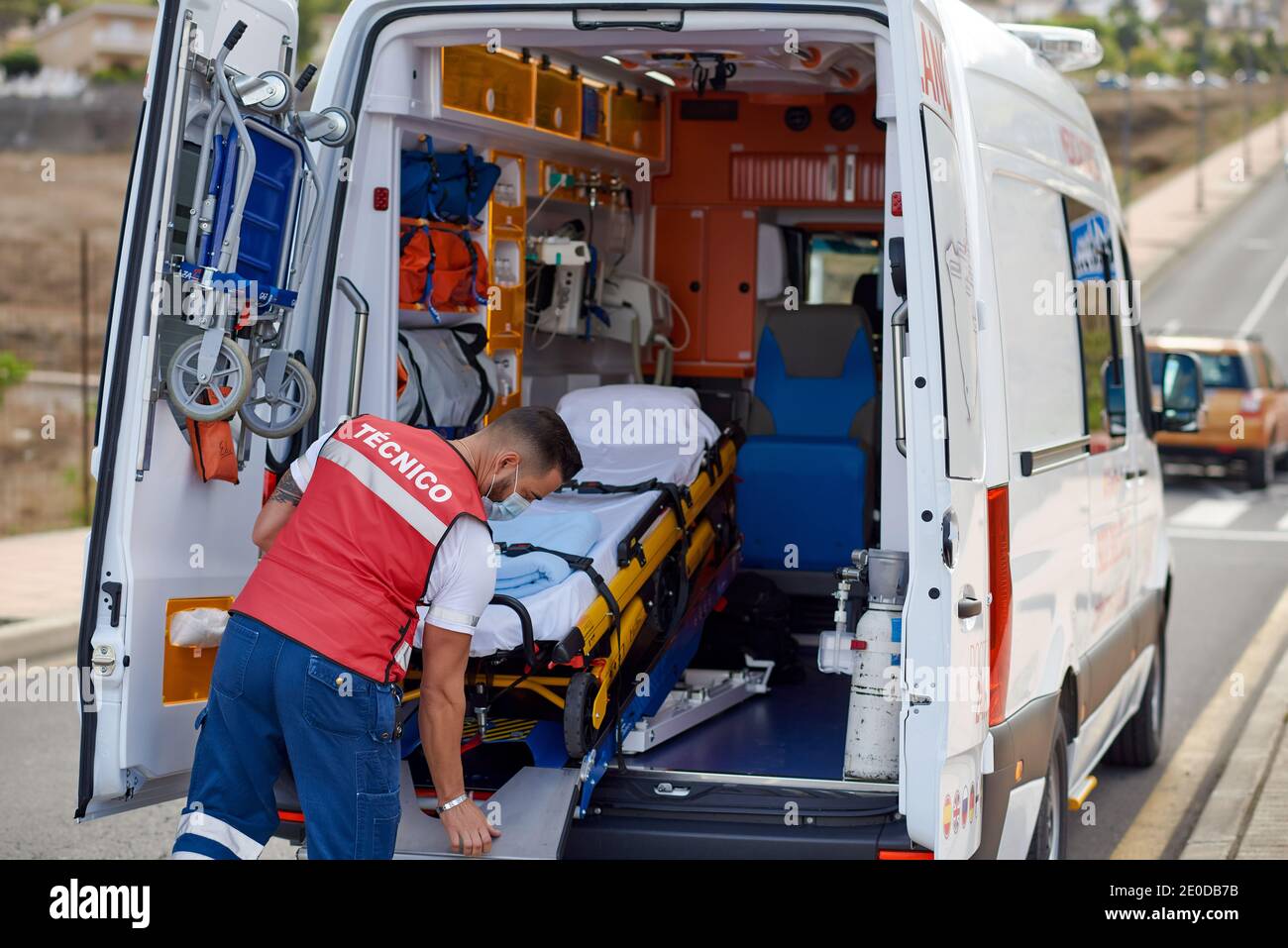 Back view of professional male paramedic in protective mask pulling ...