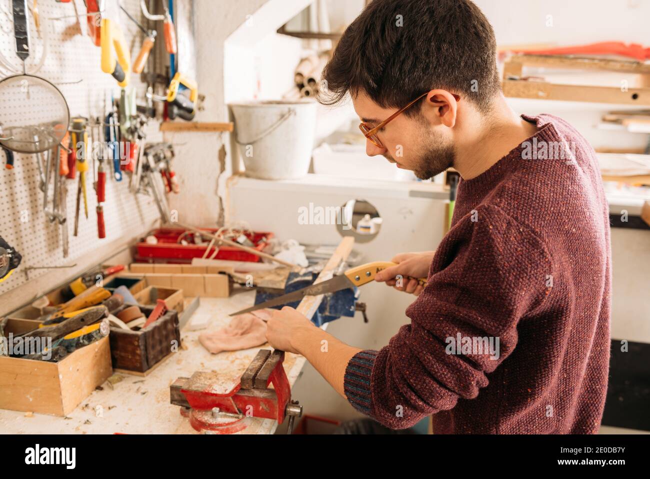 Side view high angle of busy male woodworker using sharp saw and ...