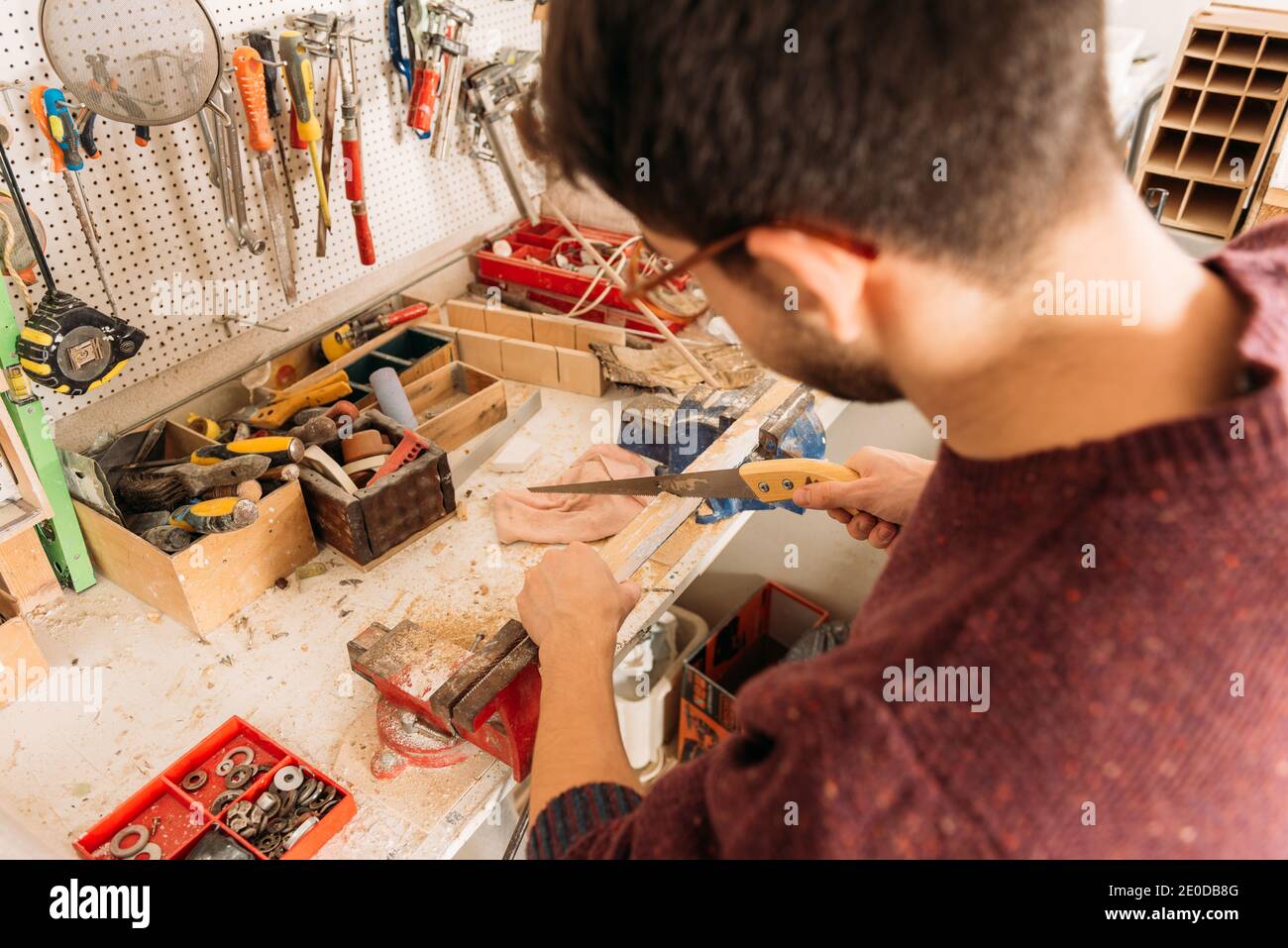 Side view high angle of busy male woodworker using sharp saw and ...