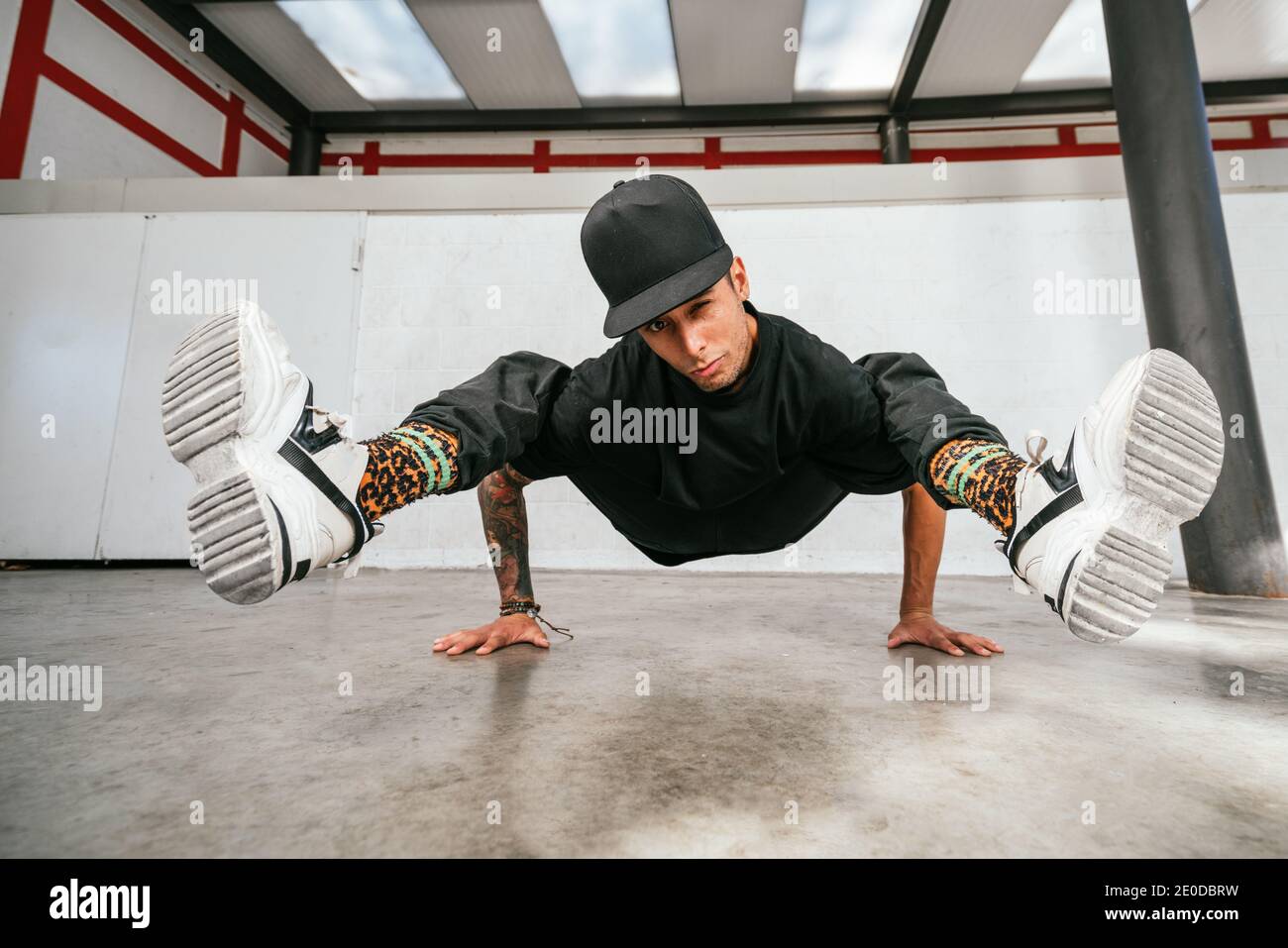 Full body of energetic young man doing acrobatic seated while ...