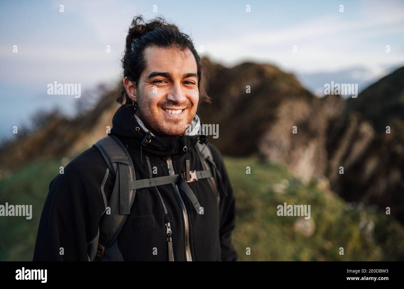 Side view of lonely male explorer with backpack standing on top of ...