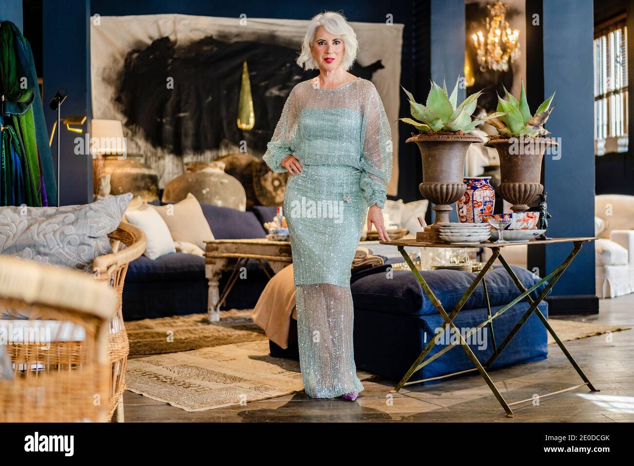 Confident mature female wearing sparkling glamour dress standing with ...