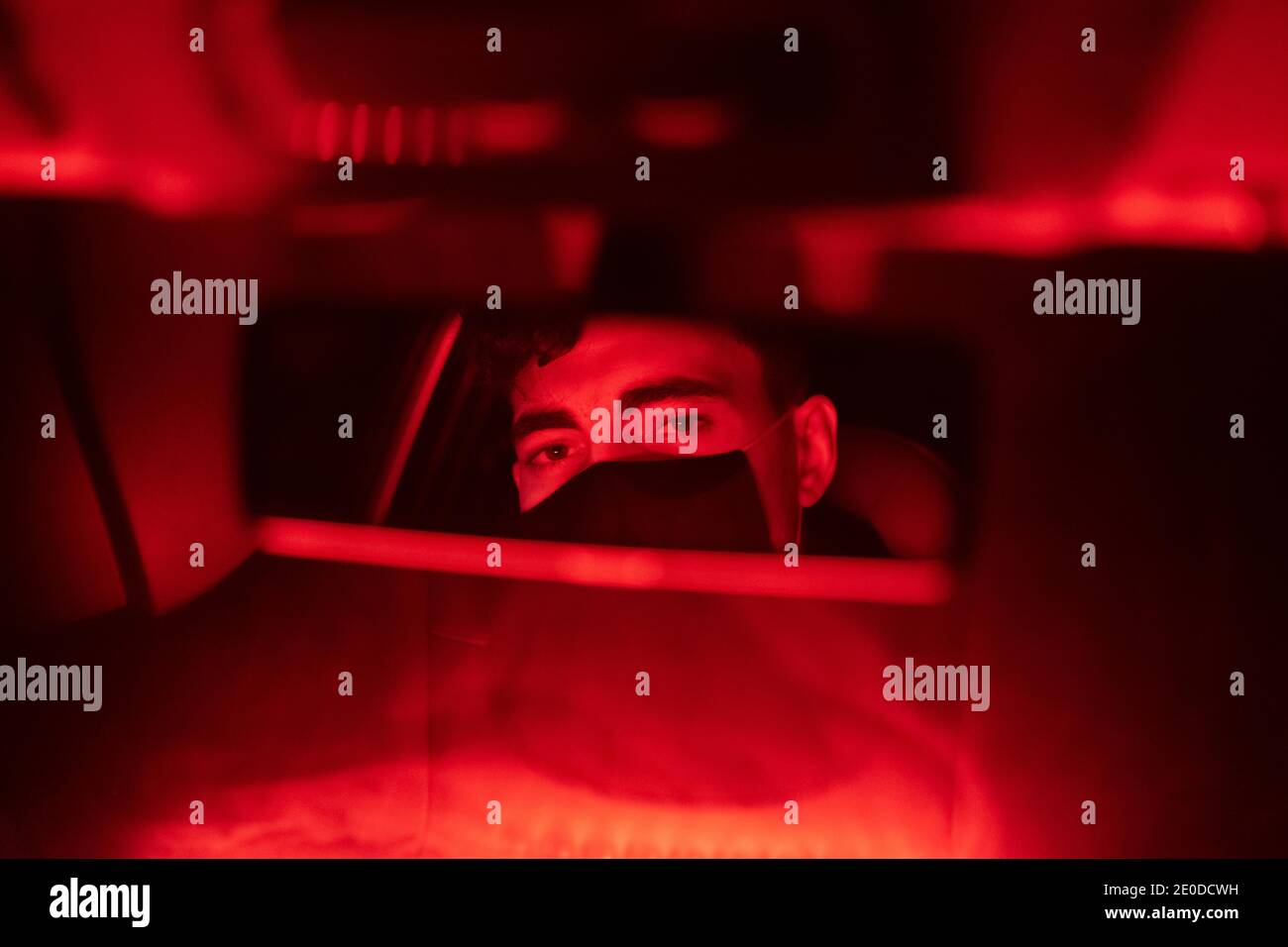 Unrecognizable concentrated young male in casual clothes and face mask ...