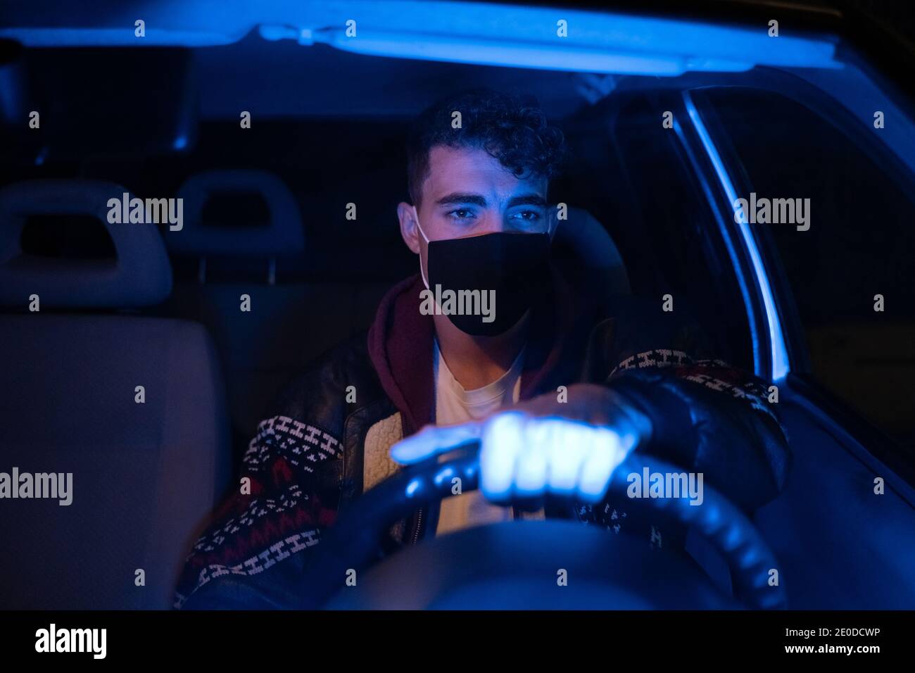 Unrecognizable concentrated young male in casual clothes and face mask ...