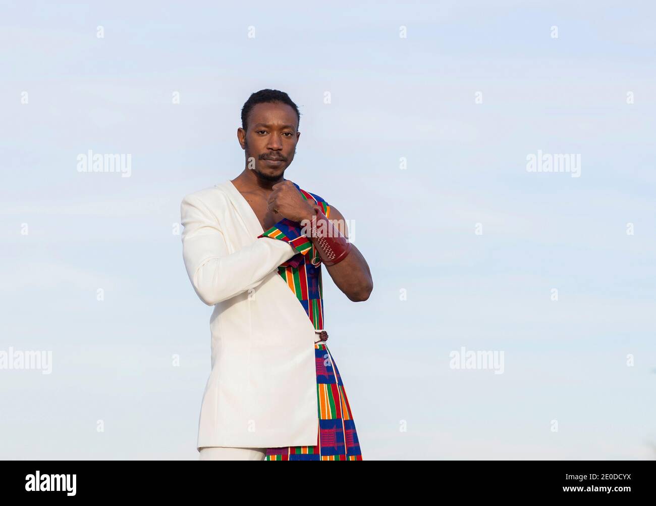 Determined African male model in traditional costume standing making ...