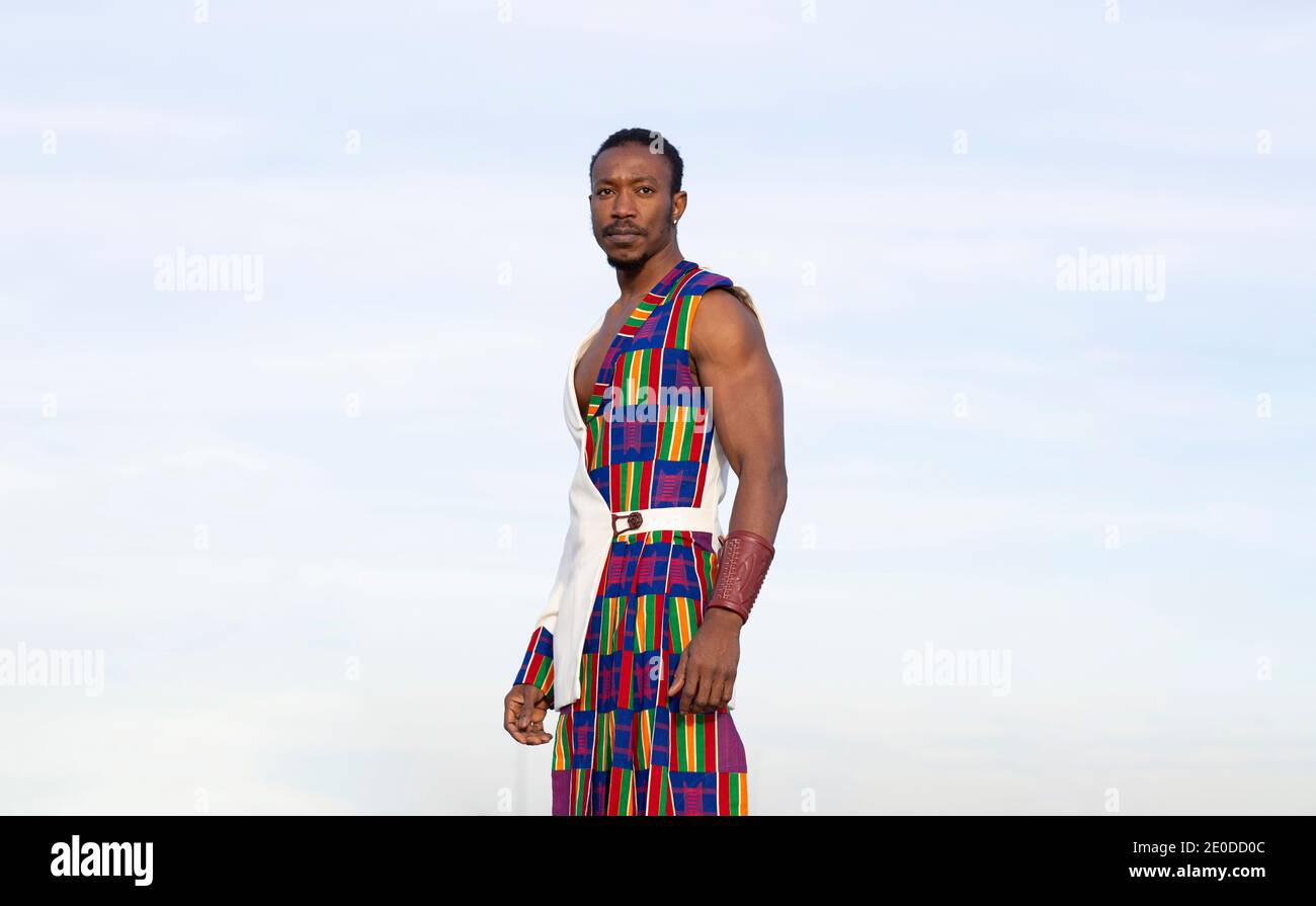Determined African American male model in traditional costume standing ...