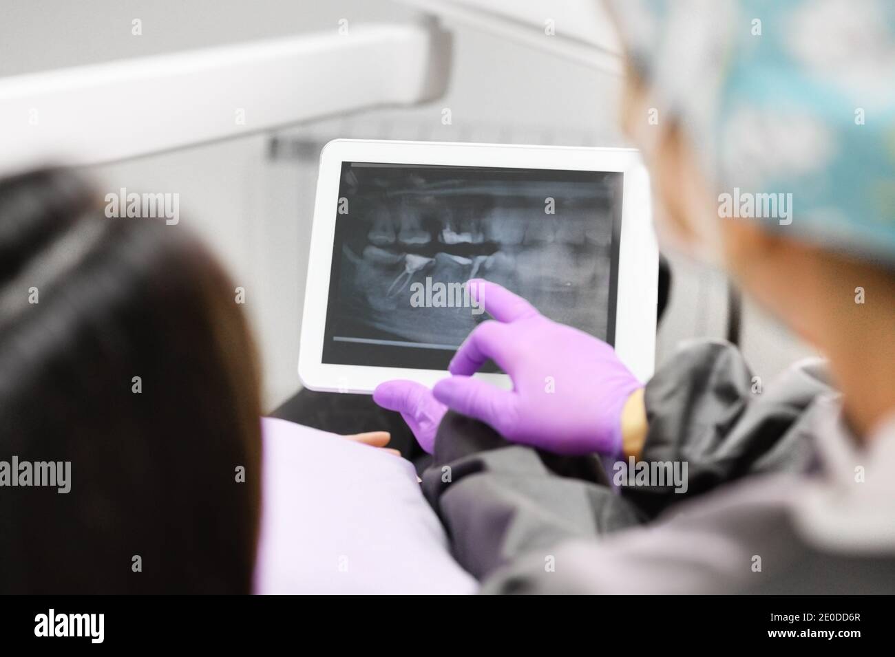 Health care concept - Female dentist showing tablet computer to woman ...
