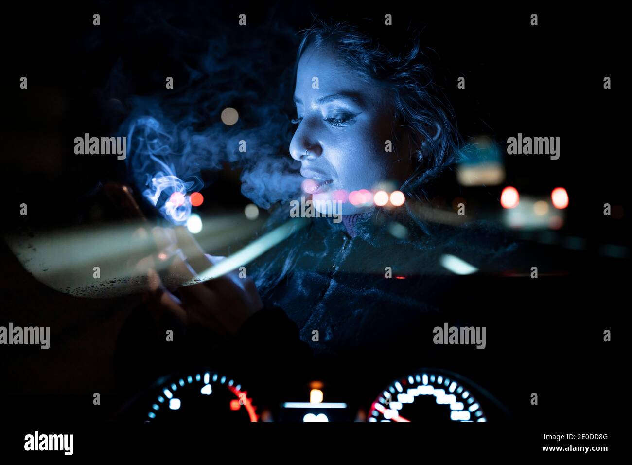 Reflection in windshield of frustrated female driver smoking while ...