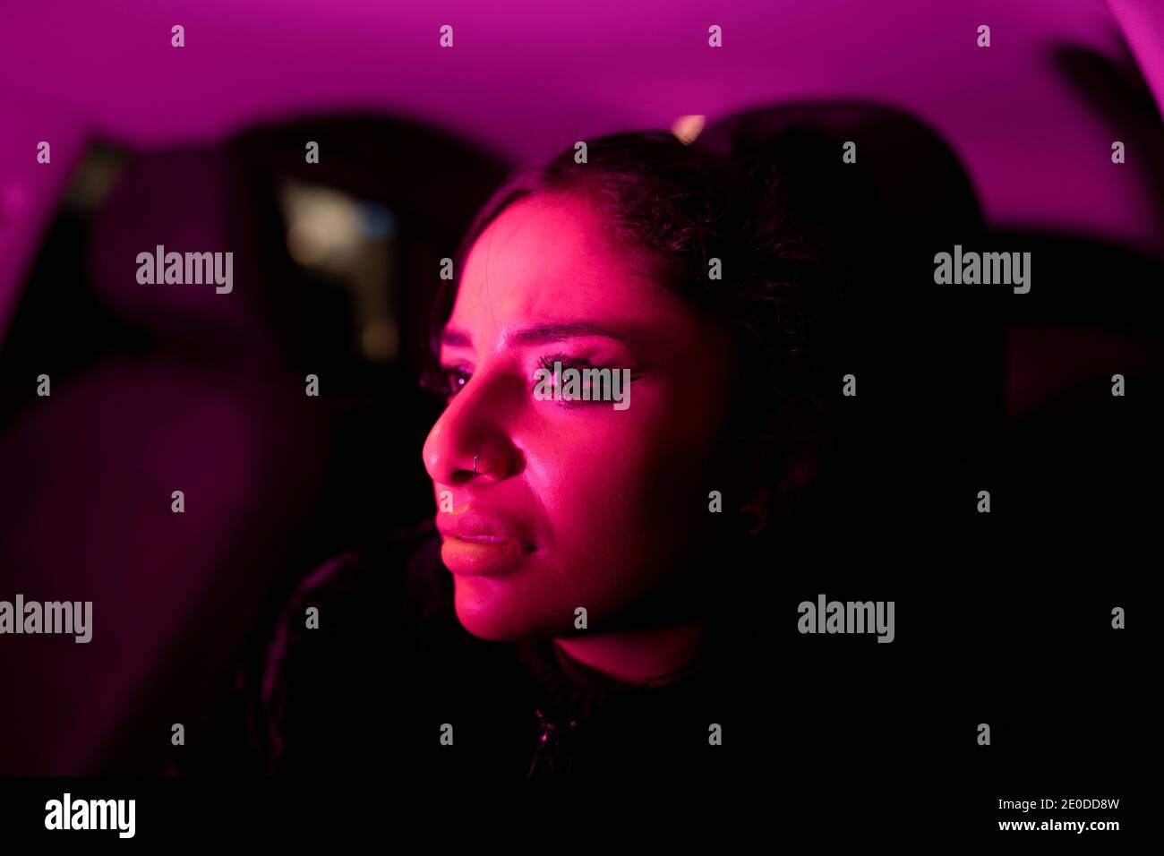 Side view of unhappy young female thinking about problems while driving ...