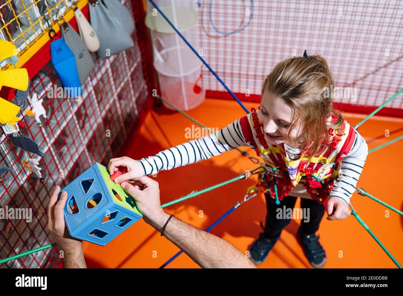 From above of little girl with Angelman syndrome playing with ...
