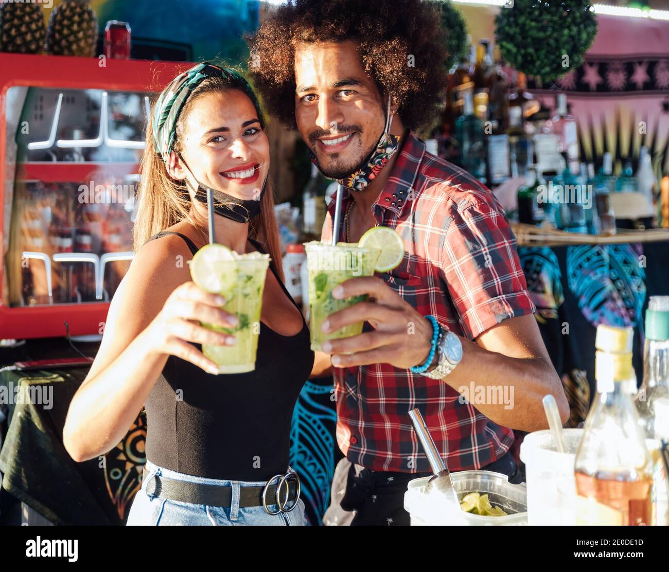 Positive ethnic owners of tropical bar looking at camera friendly and ...