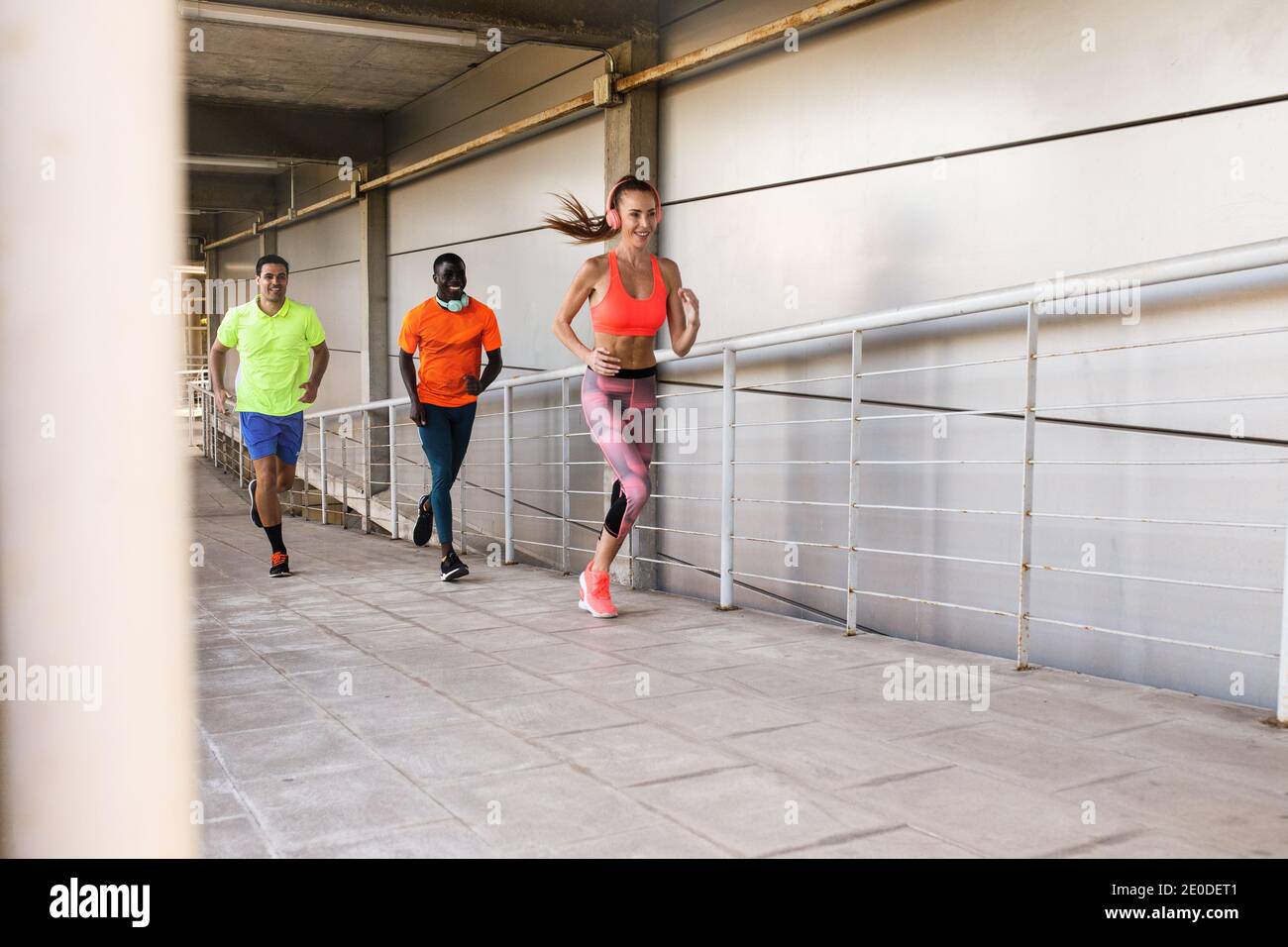Group of multiethnic runners doing cardio training while running ...